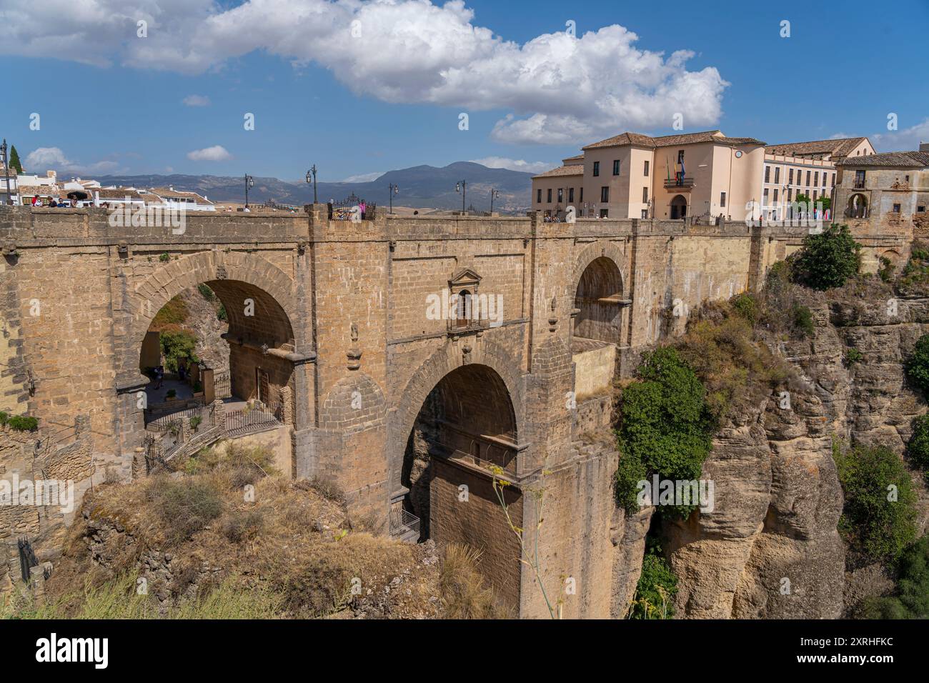 The iconic Puente Nuevo Bridge in Ronda, Spain, gracefully arches over the deep Tajo Gorge, with ...