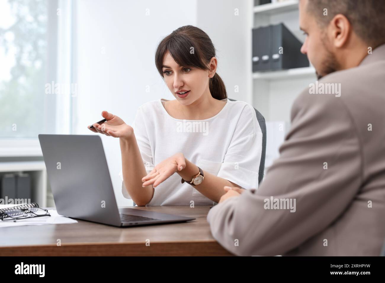 Consultant working with client at table in office. Business meeting ...