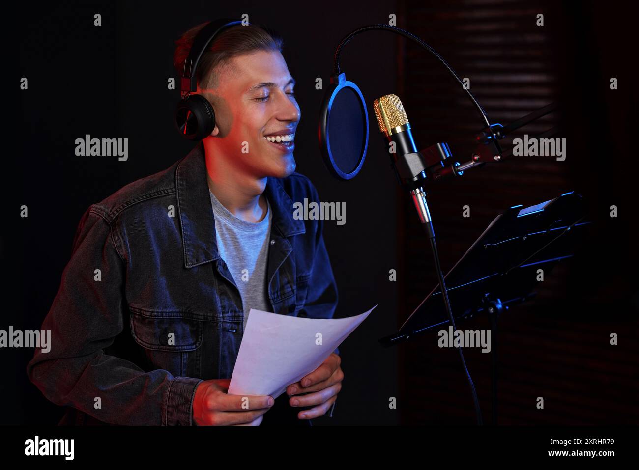 Singer with sheet recording song in professional studio Stock Photo - Alamy