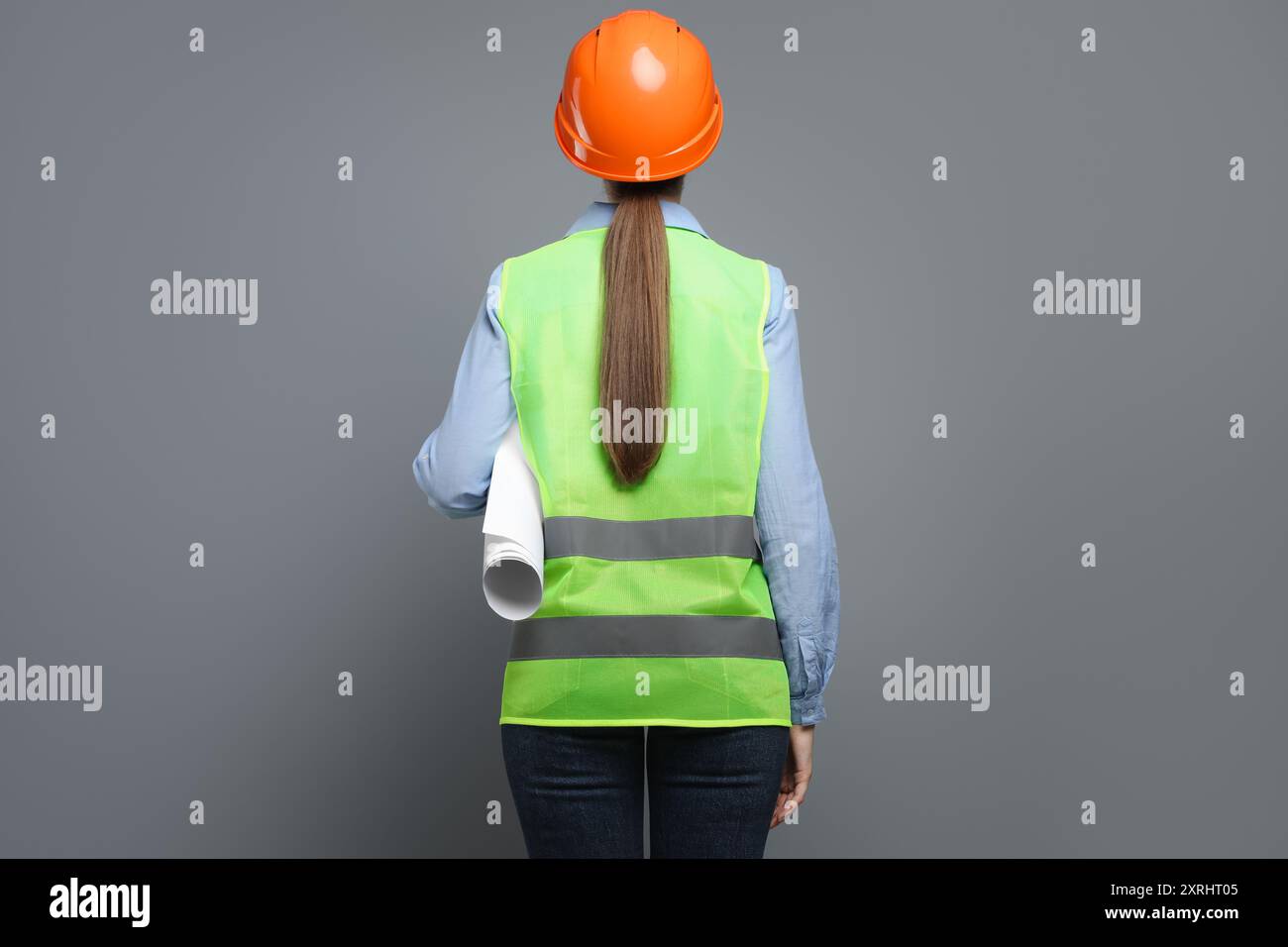 Engineer in hard hat with draft on grey background, back view Stock ...
