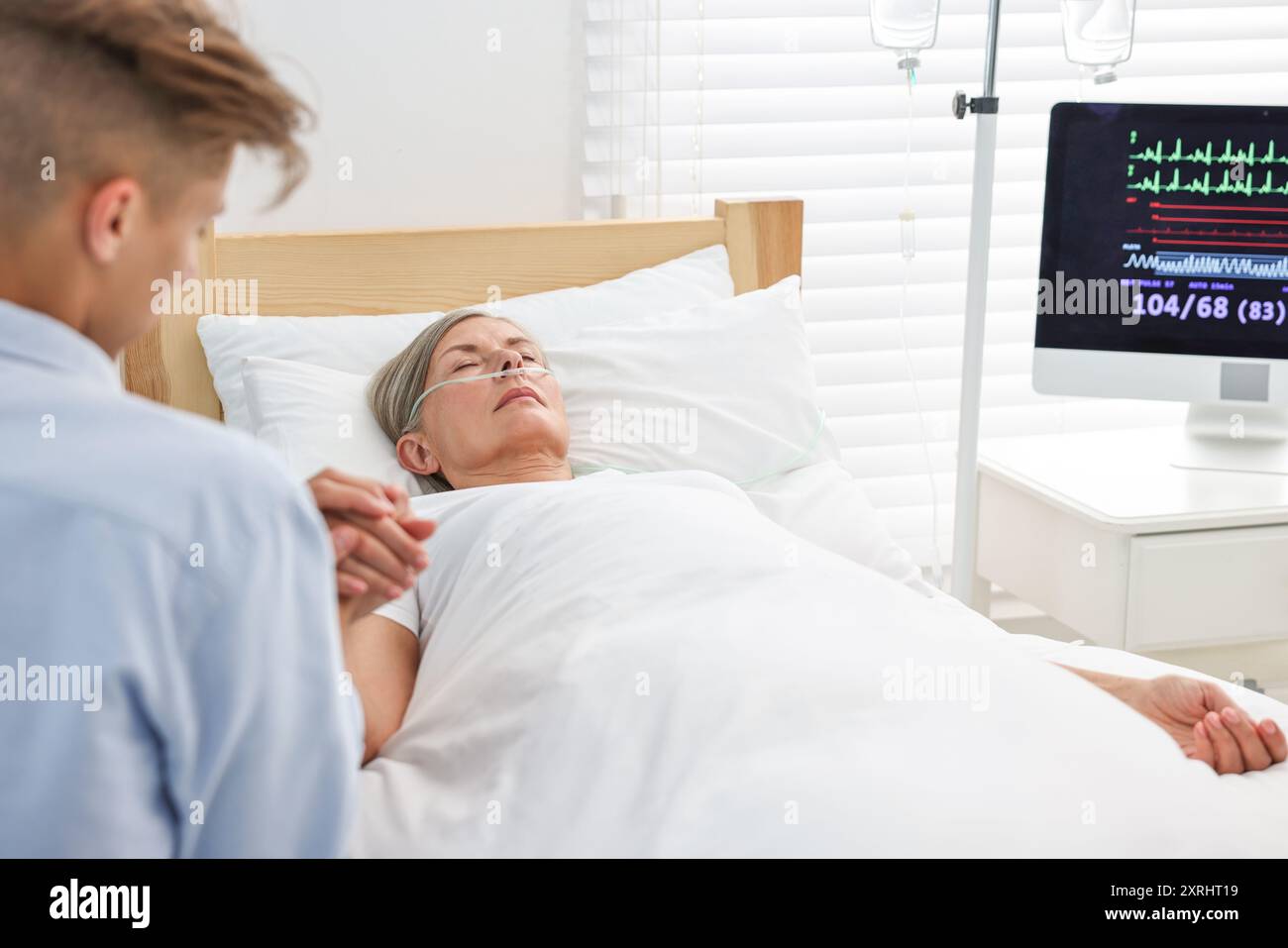 Coma patient. Man near his unconscious mother in hospital Stock Photo ...