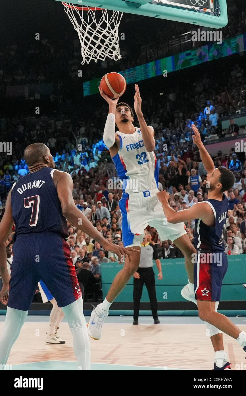 Victor Wembanyama of France (32) goes up for a shot as Kevin Durant (7) and Stephen Curry of the ...