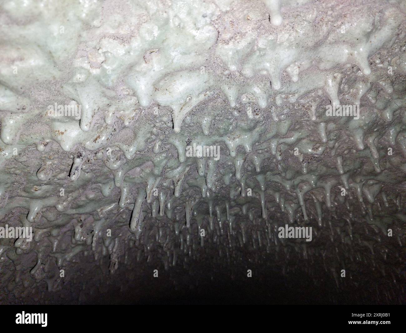 Dripping fused material textures create unique formations in a dimly ...