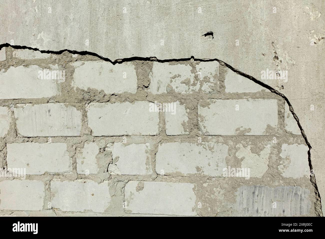 Textured plaster wall with visible cracks and uneven surface detailing ...