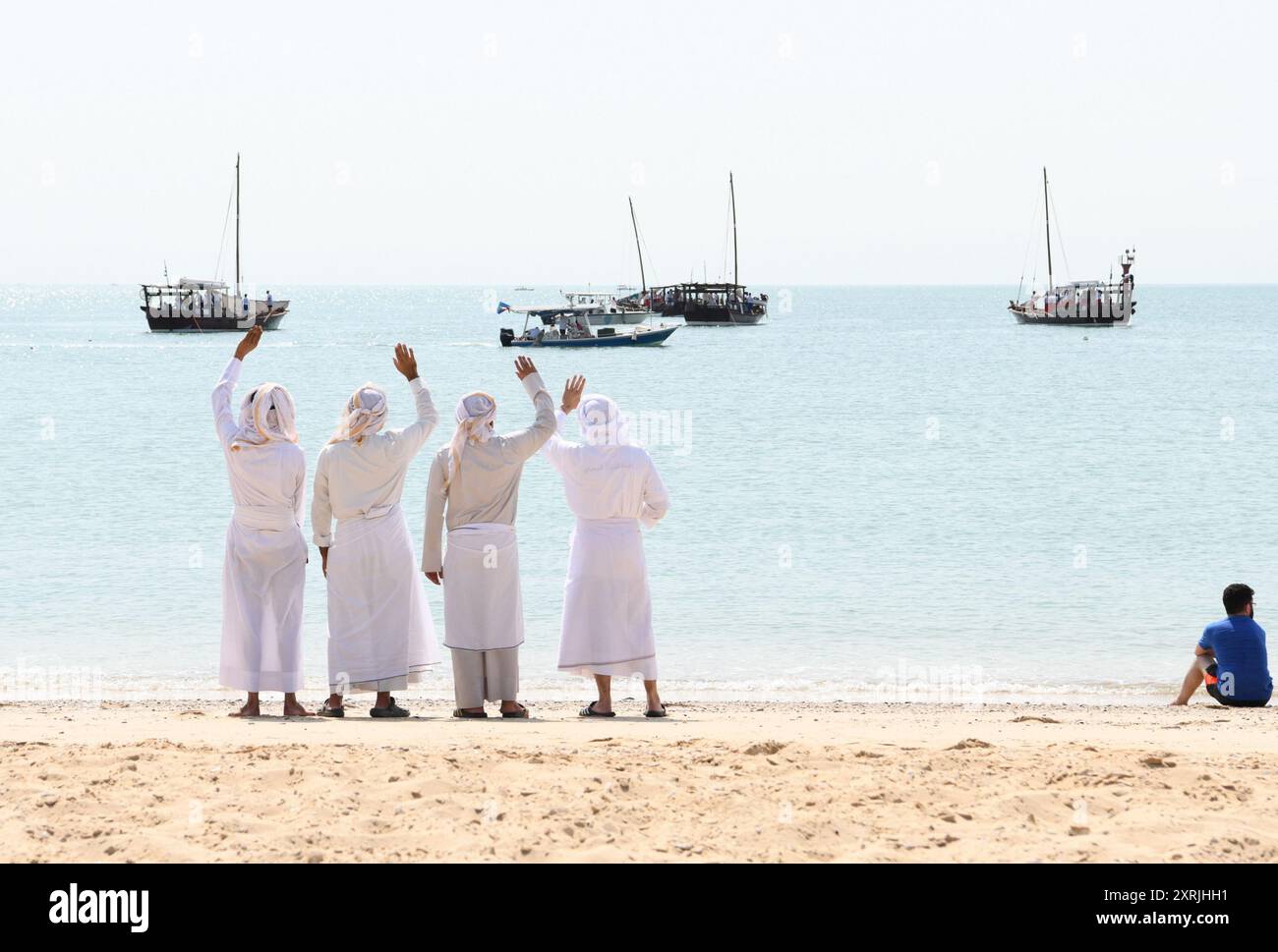 Hawalli Governorate, Kuwait. 10th Aug, 2024. People wave to dhow boats ...