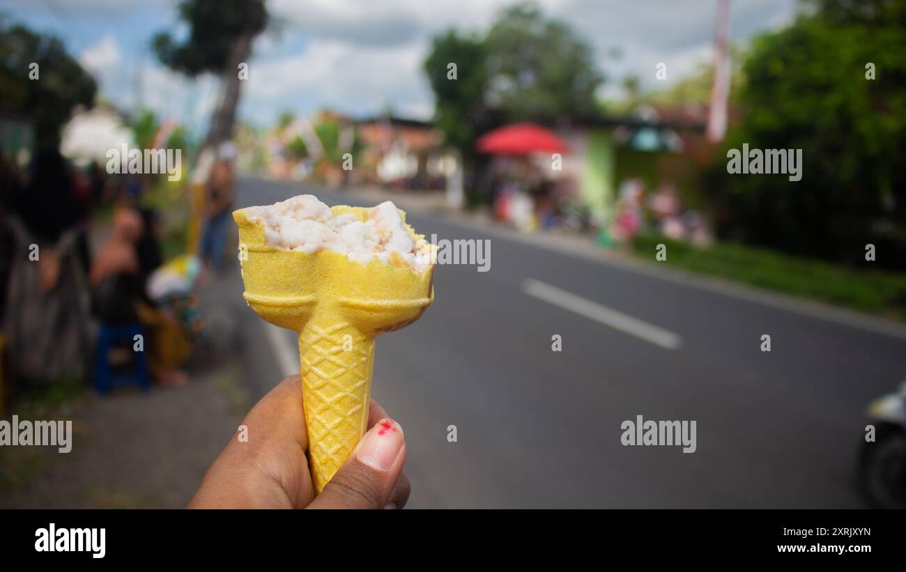 hand holding eaten soft ice cream cone against busy street backdrop on ...