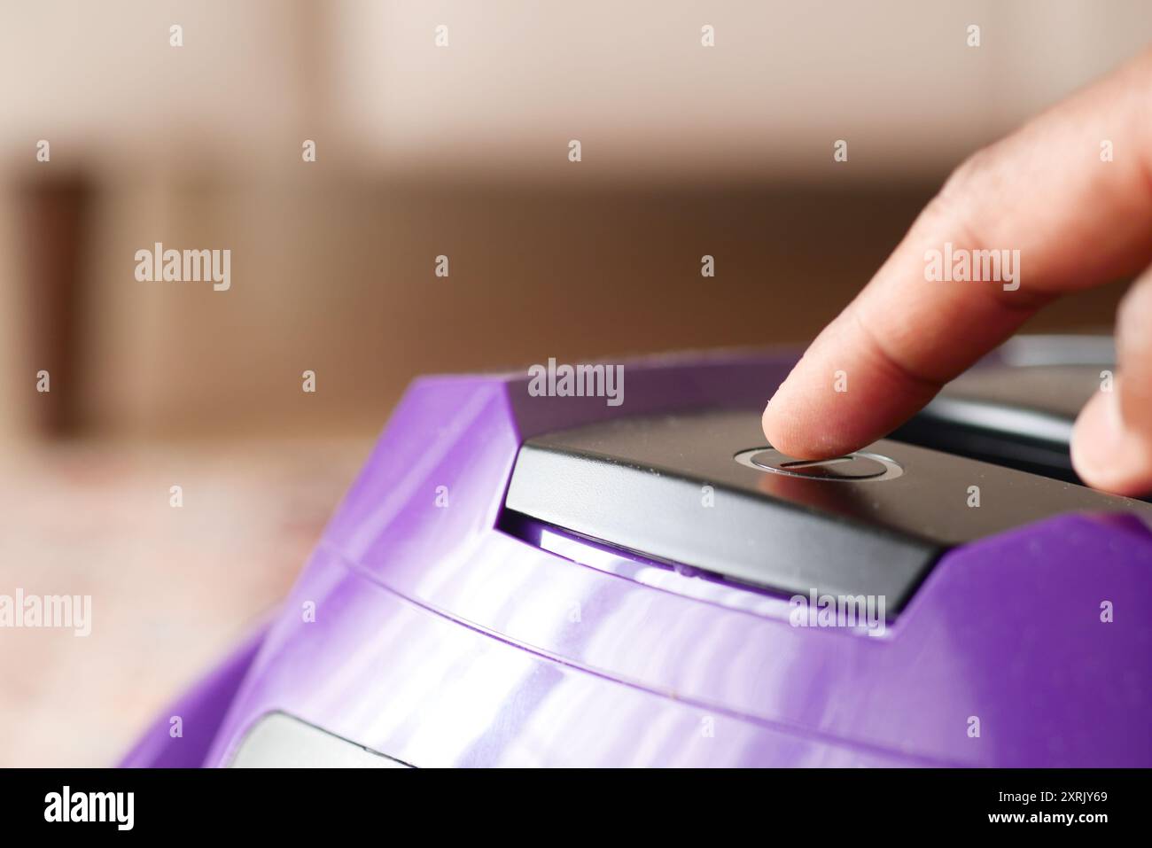 pressing start button on vacuum cleaner Stock Photo - Alamy