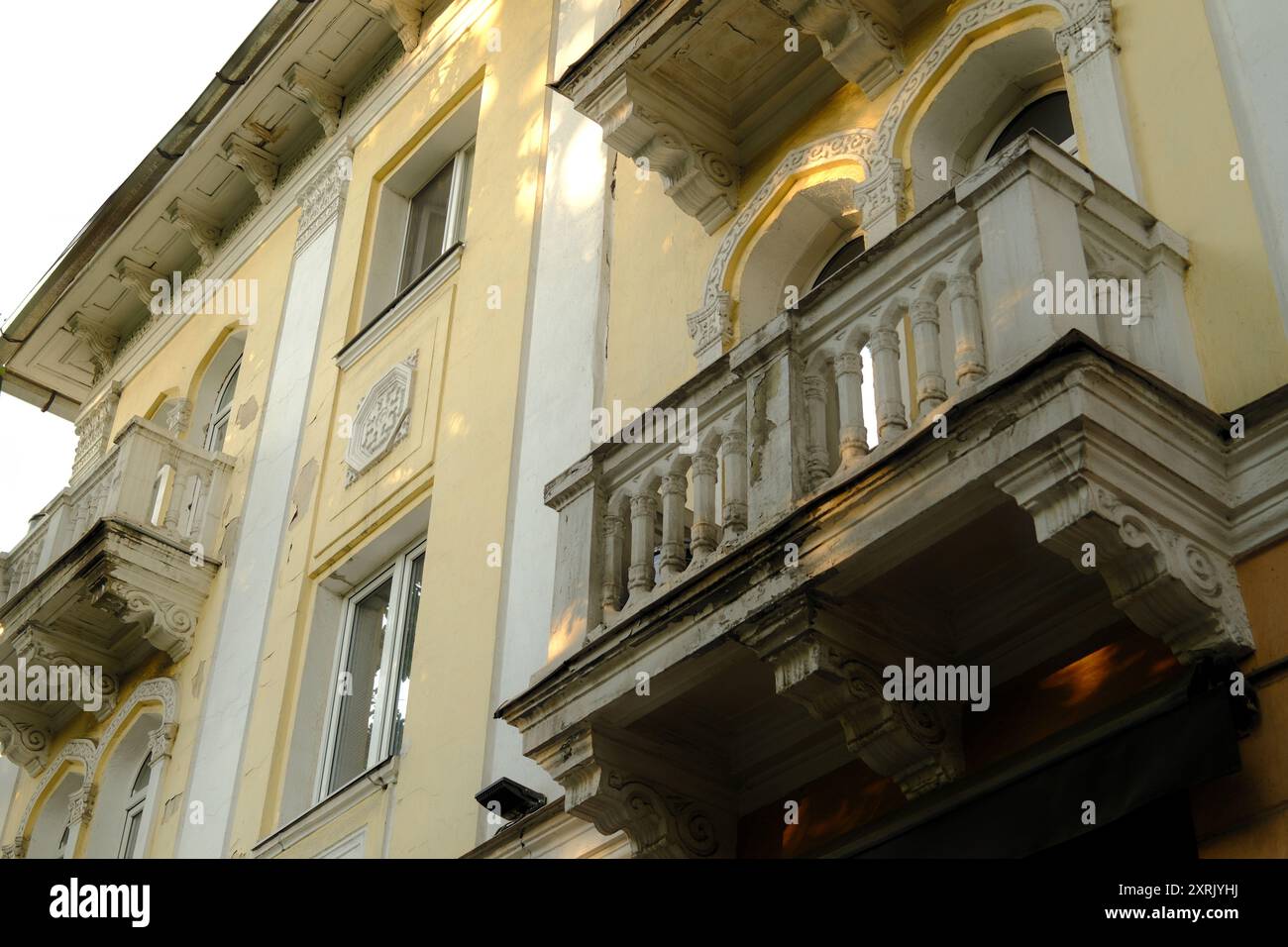 Elegant Yellow Building Facade with Intricate White Balconies, Arches ...