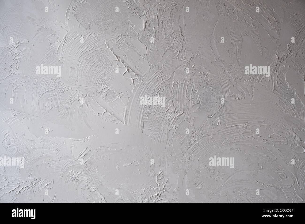 Applying decorative putty. White abstract texture of surface covered ...