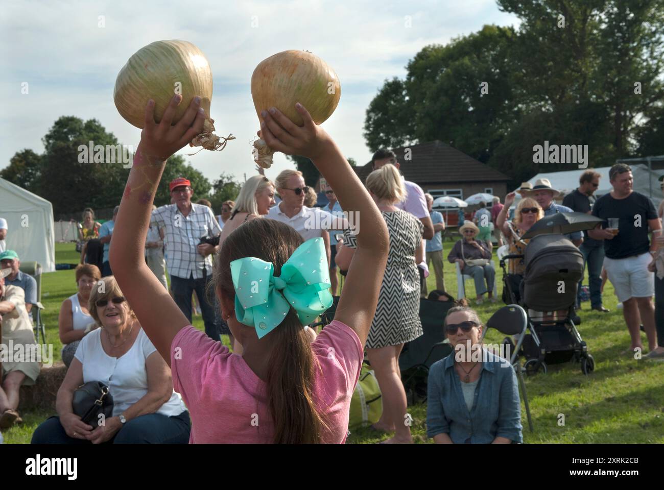 Village fair and fete, teen girl with Best in Show giant onions. They ...