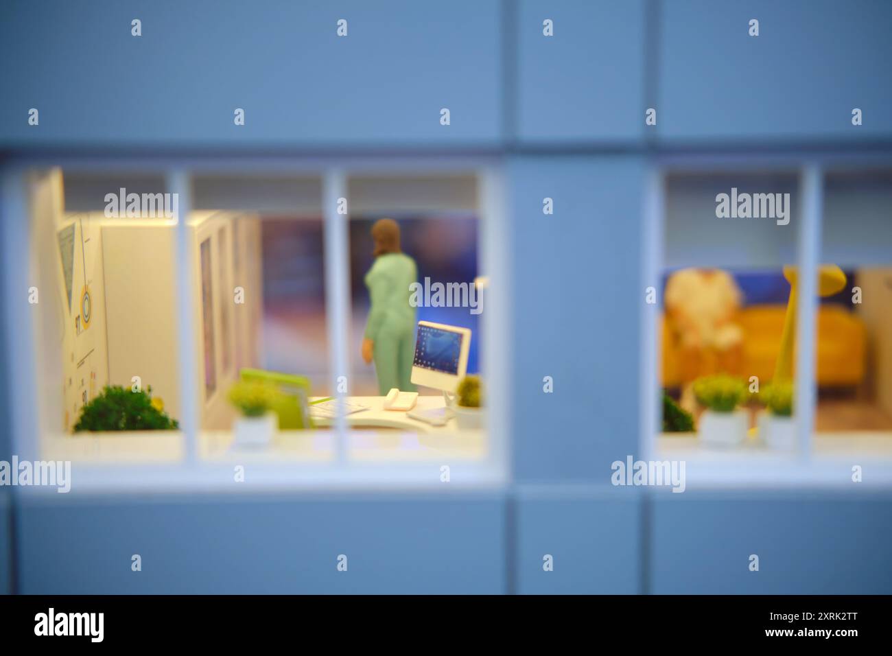 Miniature figure of a person standing in an office with a desk and ...
