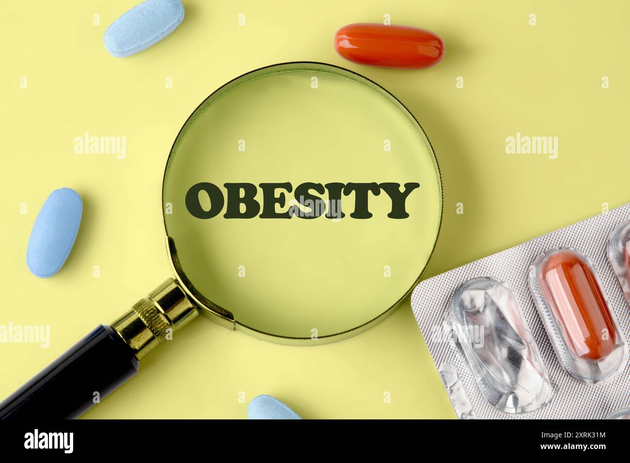 OBESITY word alphabet letters through a magnifying glass in a ...