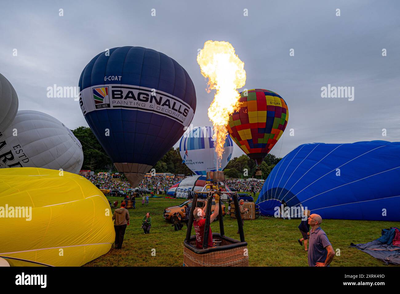 Hot air balloons flash the burners as they prepare to lift off at the ...