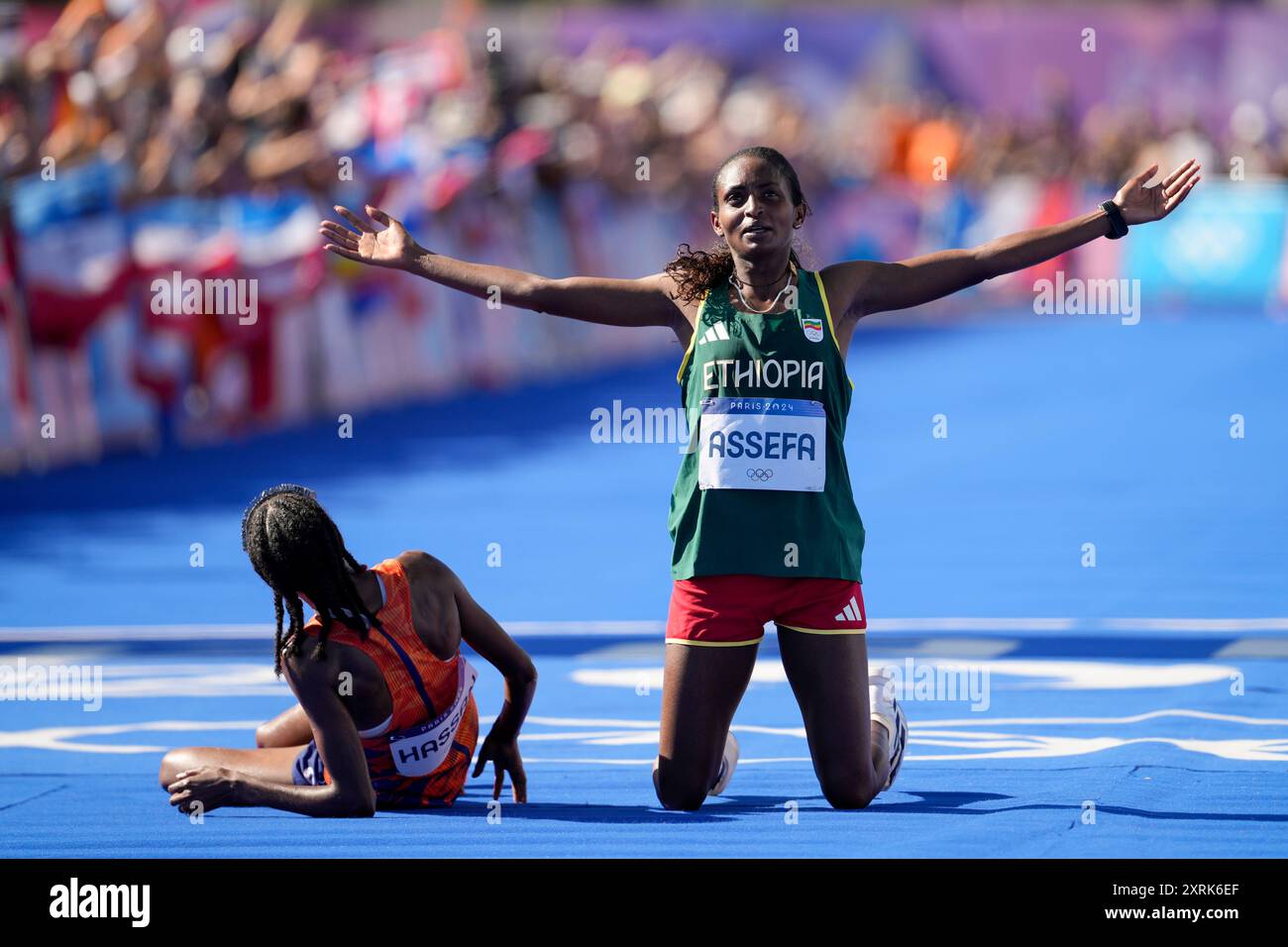 Ethiopia's Tigst Assefa, right, celebrates after crossing the finish ...