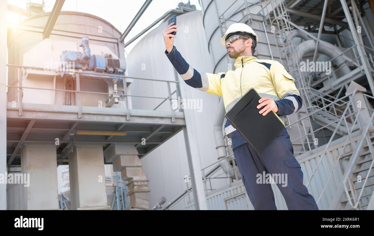 Engineer taking a photo with his mobile phone in a factory. Inspection ...