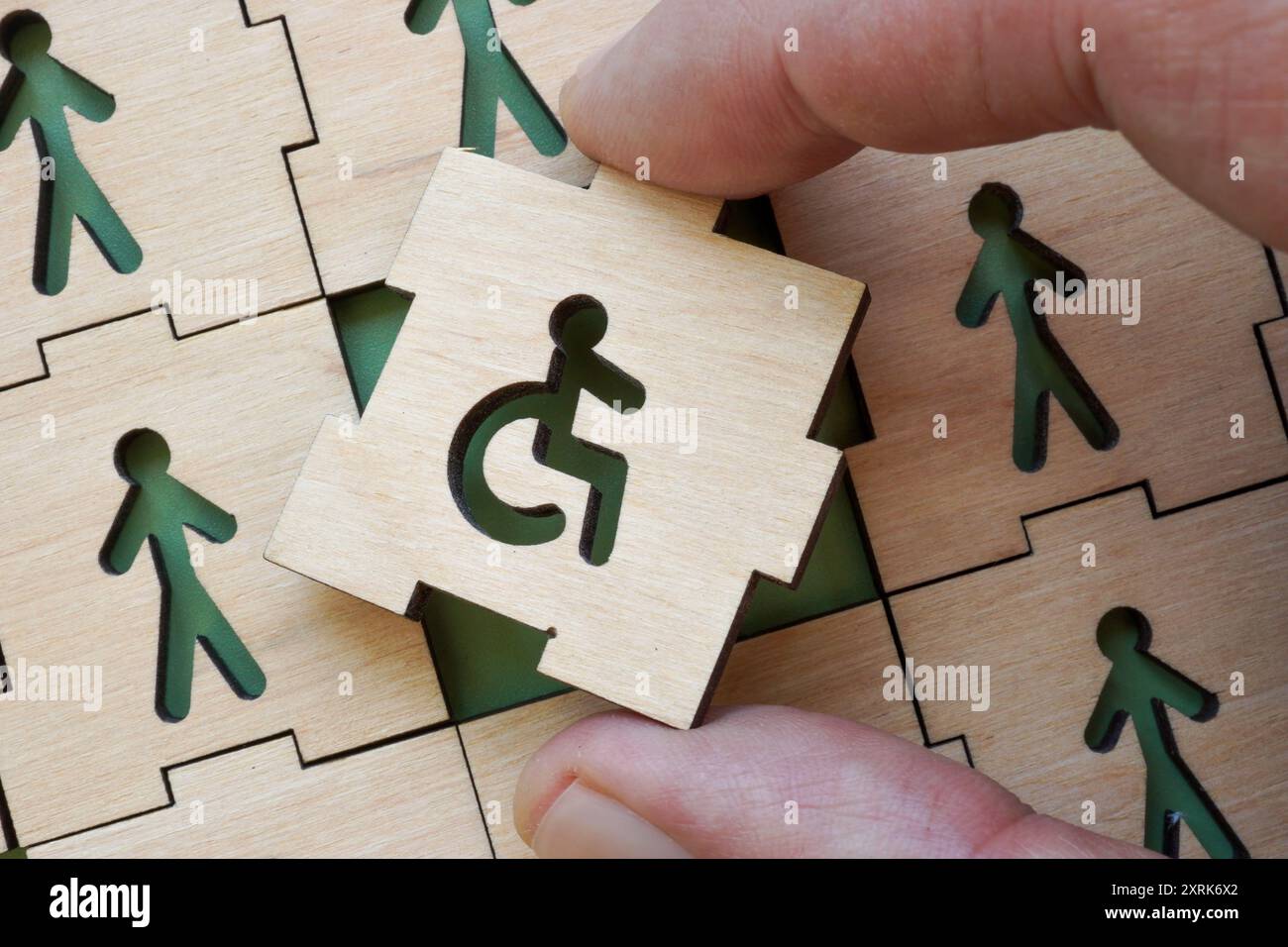 Hand holding puzzle piece with disability symbol. Concept of inclusion ...