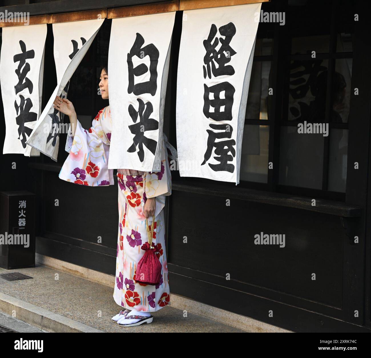 Young Japanese girl with the traditional yukata on the facade of an ...