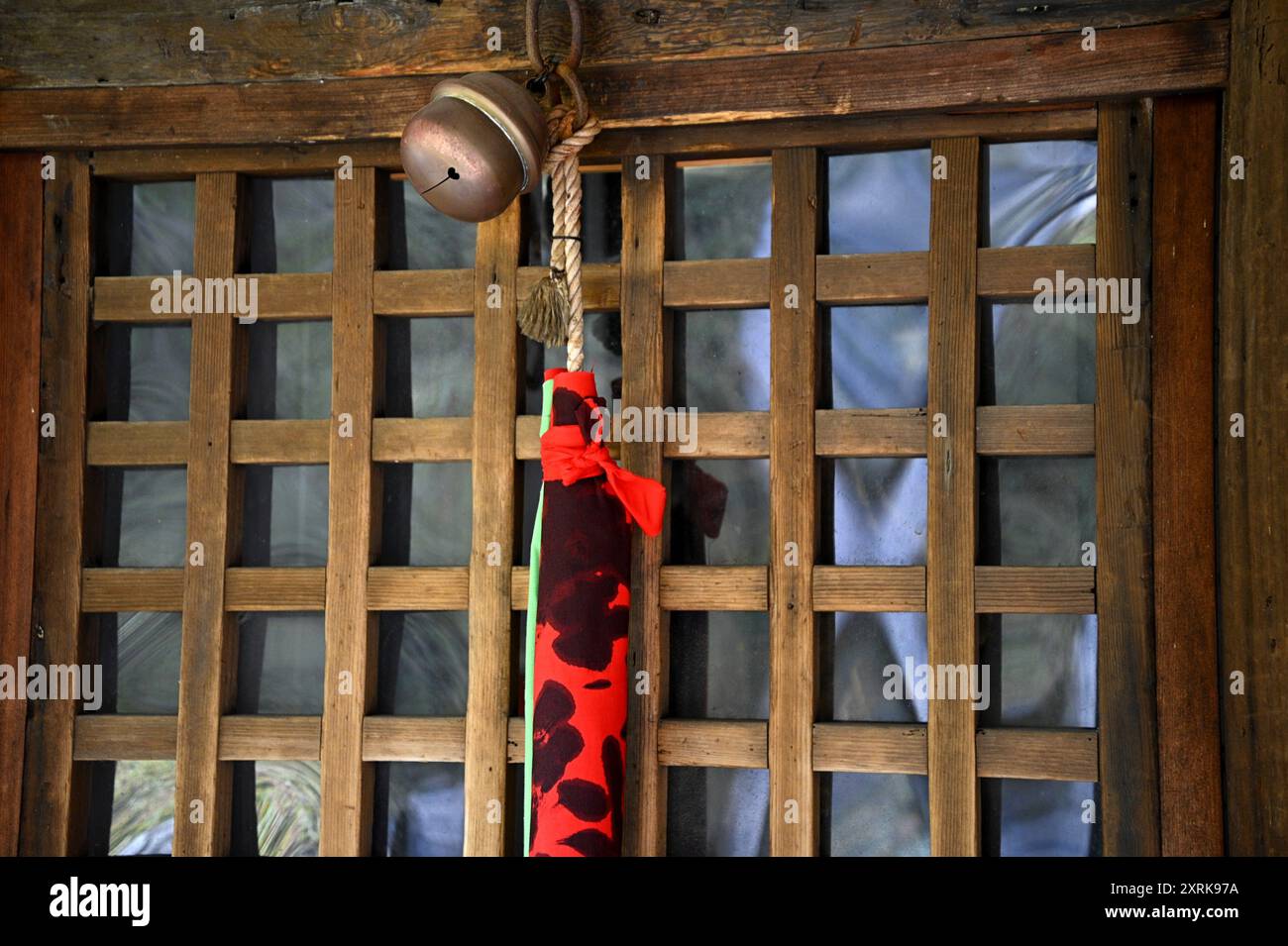 Antique cedar wooden door with a vintage bronze Shinto bell on the ...