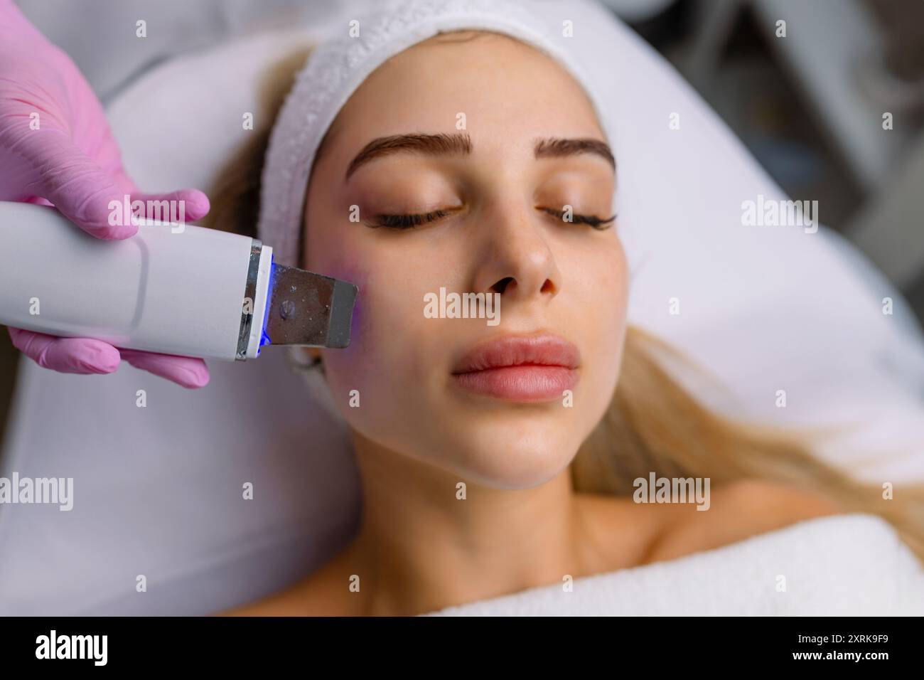 Facial cleansing with ultrasound scrubber. Woman receiving ultrasound ...