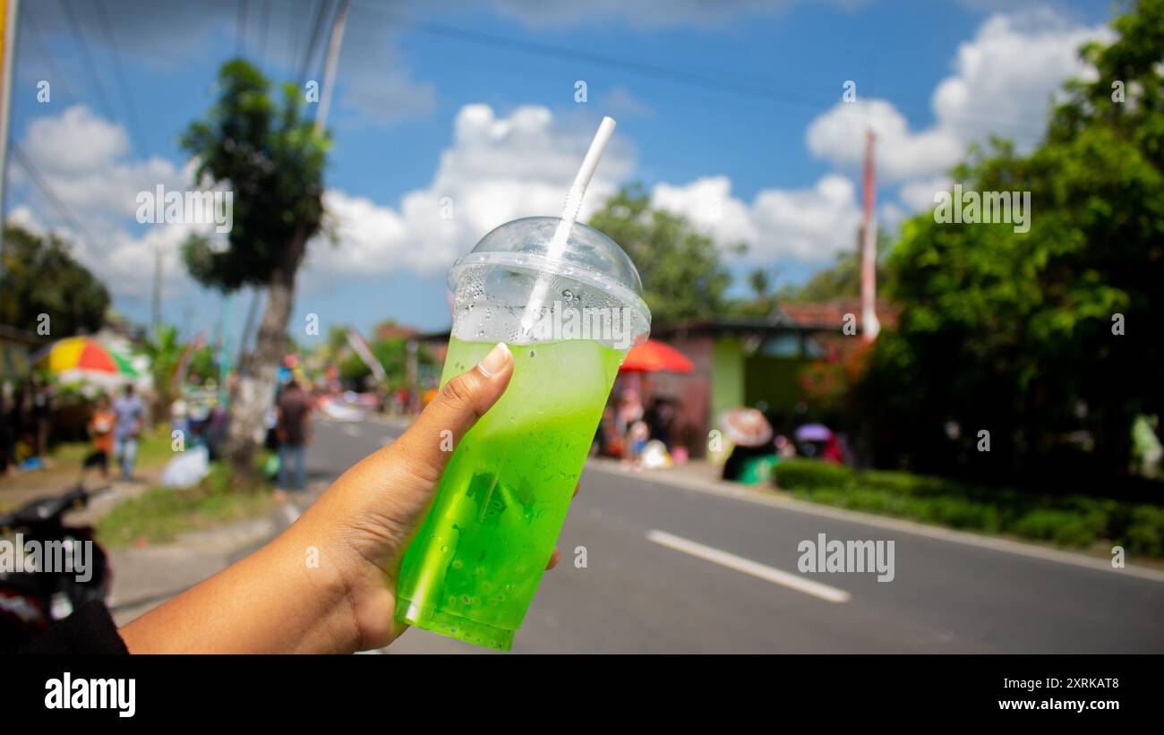 A refreshing to go cup of melon flavored iced held up against the ...