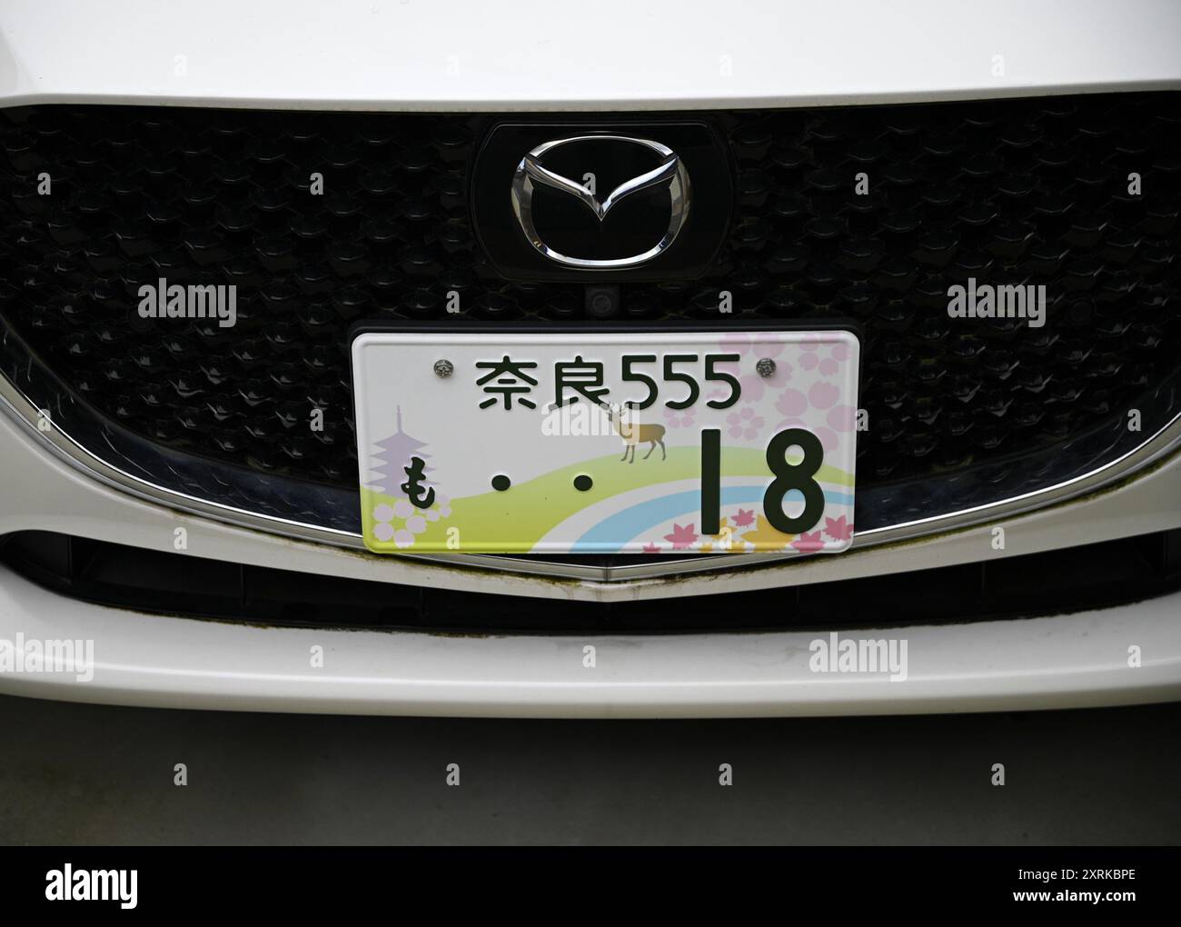 Japanese vehicle registration licensed plates on the hood of a Mazda ...