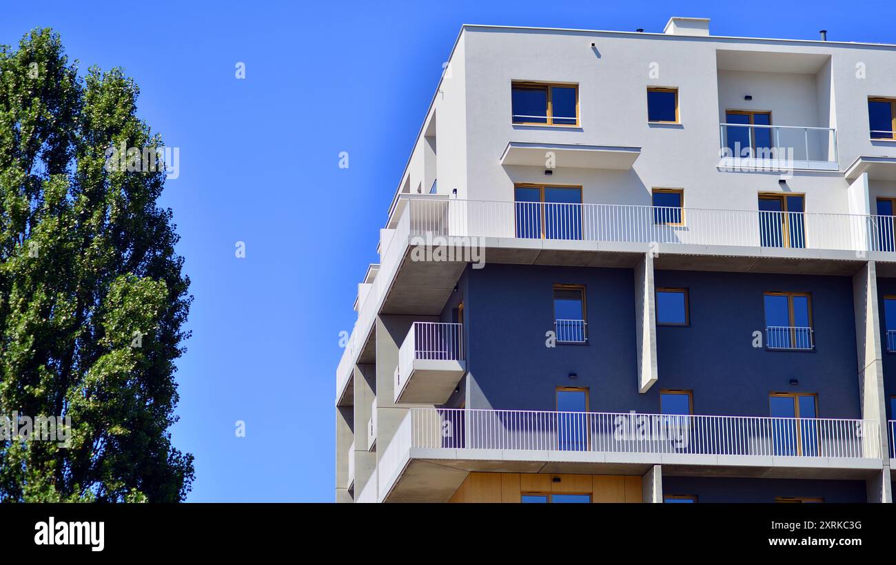 New modern block of flats in green area. Eco apartment building saving ...