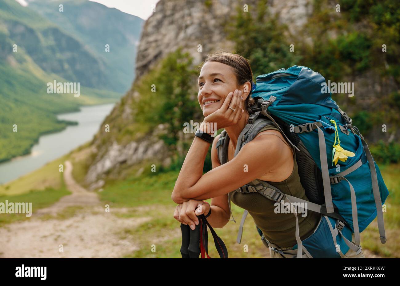 A woman is hiking through a stunning and scenic mountain landscape ...