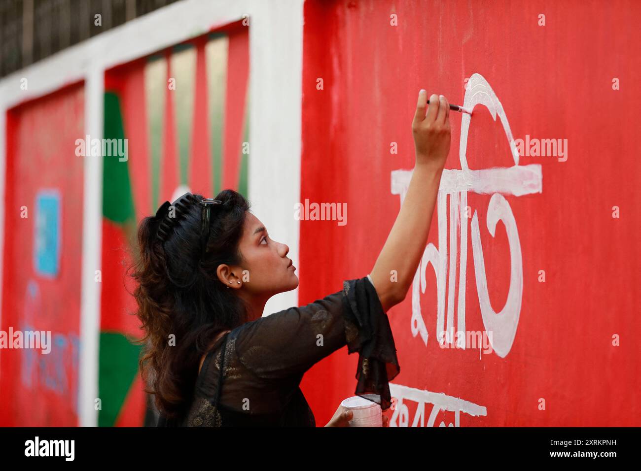 Students paint a new graffiti on a street wall in Dhaka, Bangladesh ...