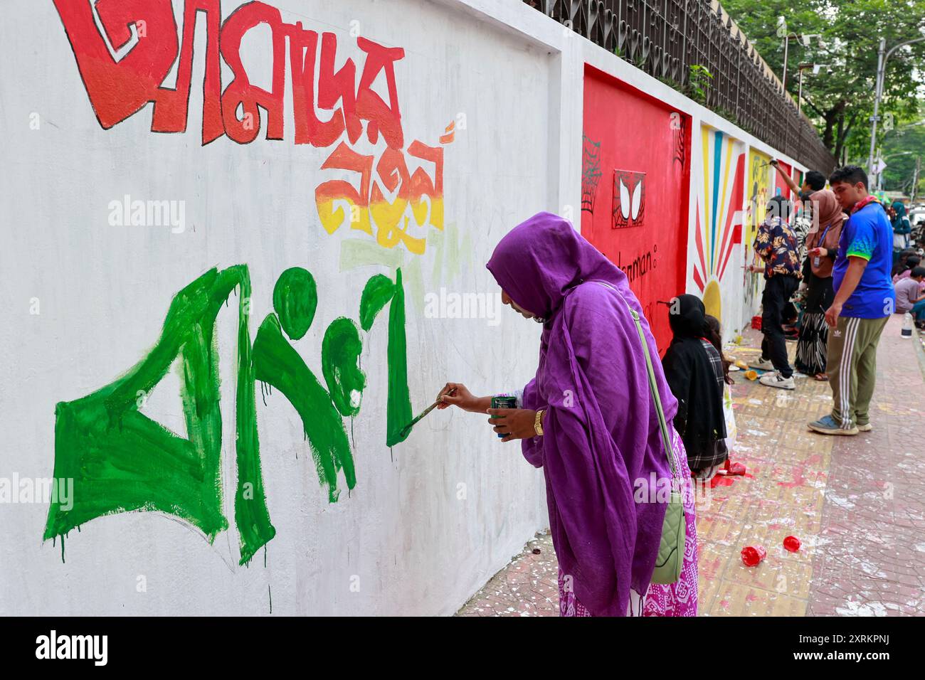 Students paint a new graffiti on a street wall in Dhaka, Bangladesh ...