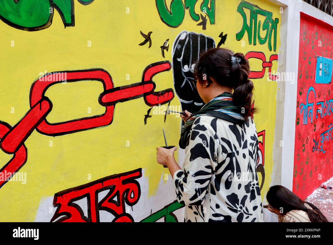 Students paint a new graffiti on a street wall in Dhaka, Bangladesh ...