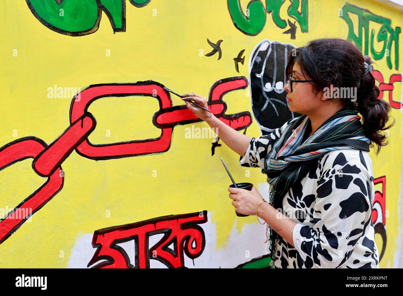 Students paint a new graffiti on a street wall in Dhaka, Bangladesh ...