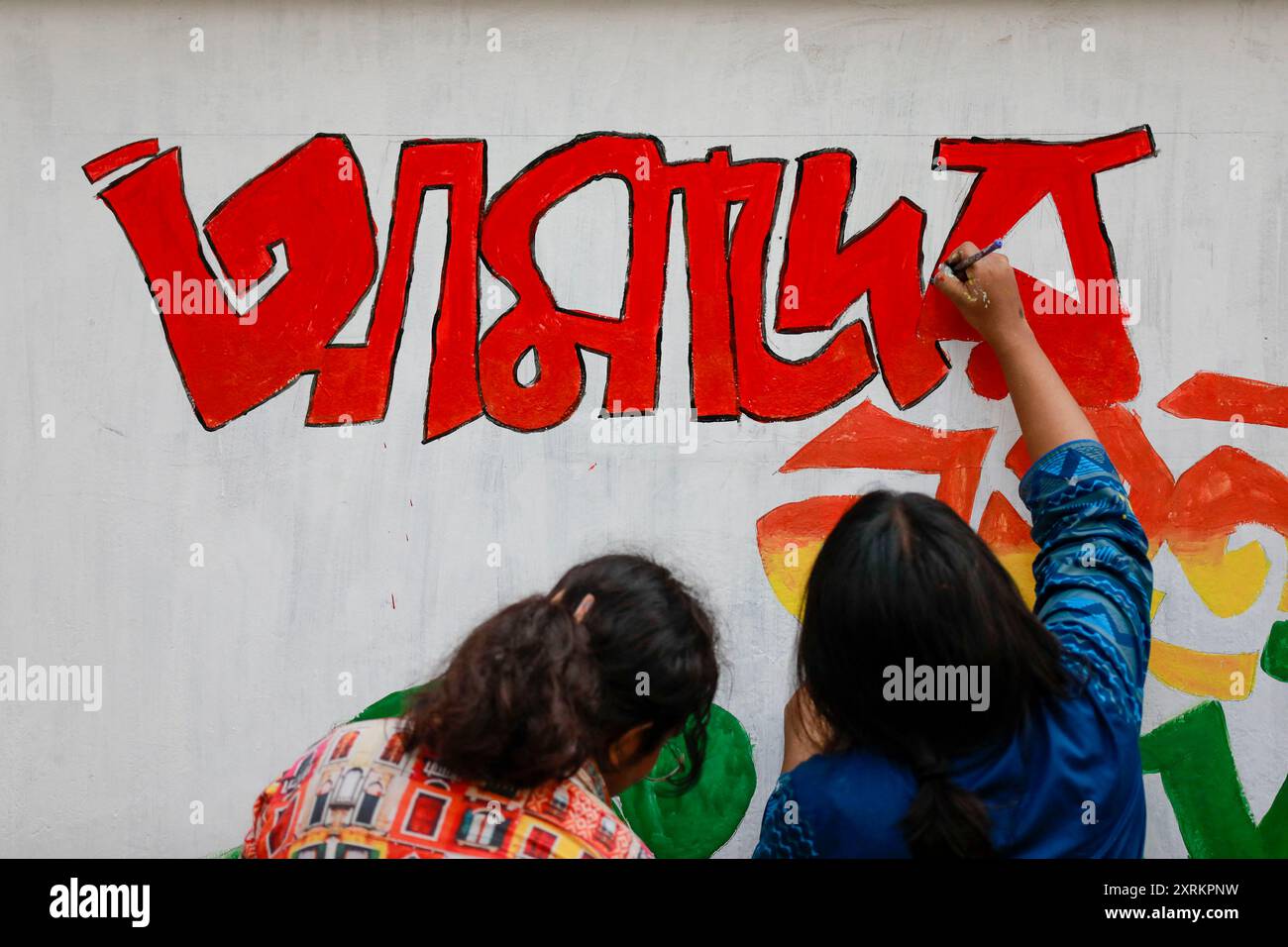 Students paint a new graffiti on a street wall in Dhaka, Bangladesh ...