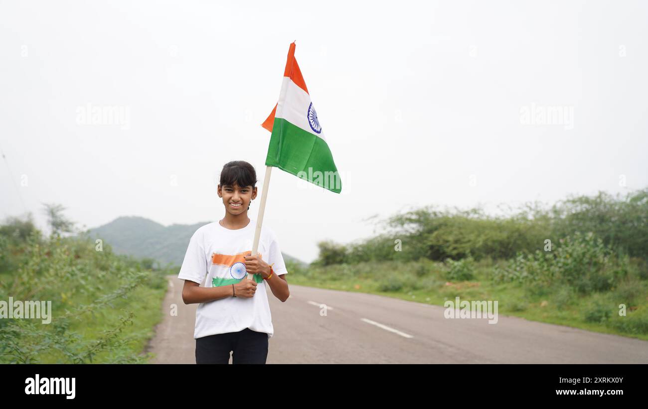 Cute Indian girl holding Indian flag in her hand and smiling ...