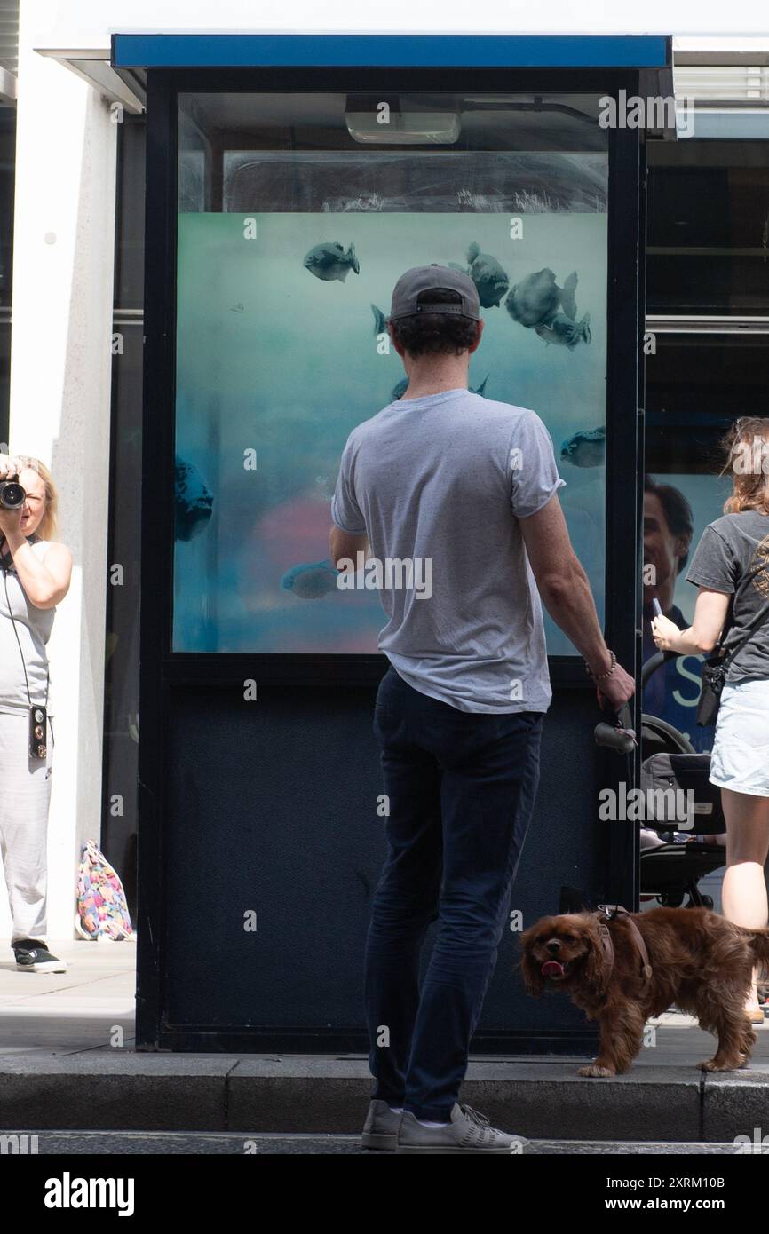 London, UK. 11 Aug 2024. People take photos of a seventh new mural by ...