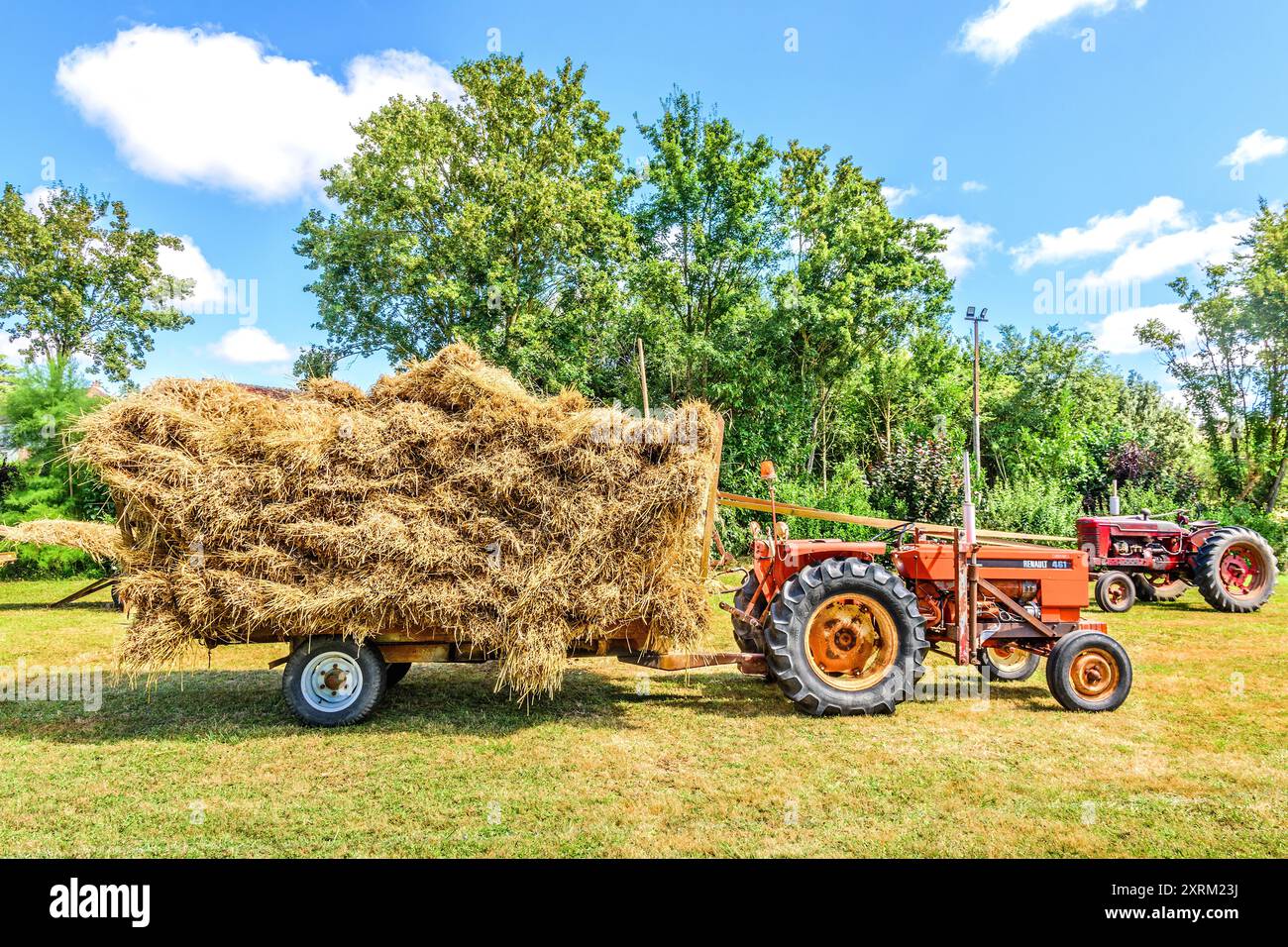 Farm wagon loaded with straw towed by old Renault 461 tractor at ...