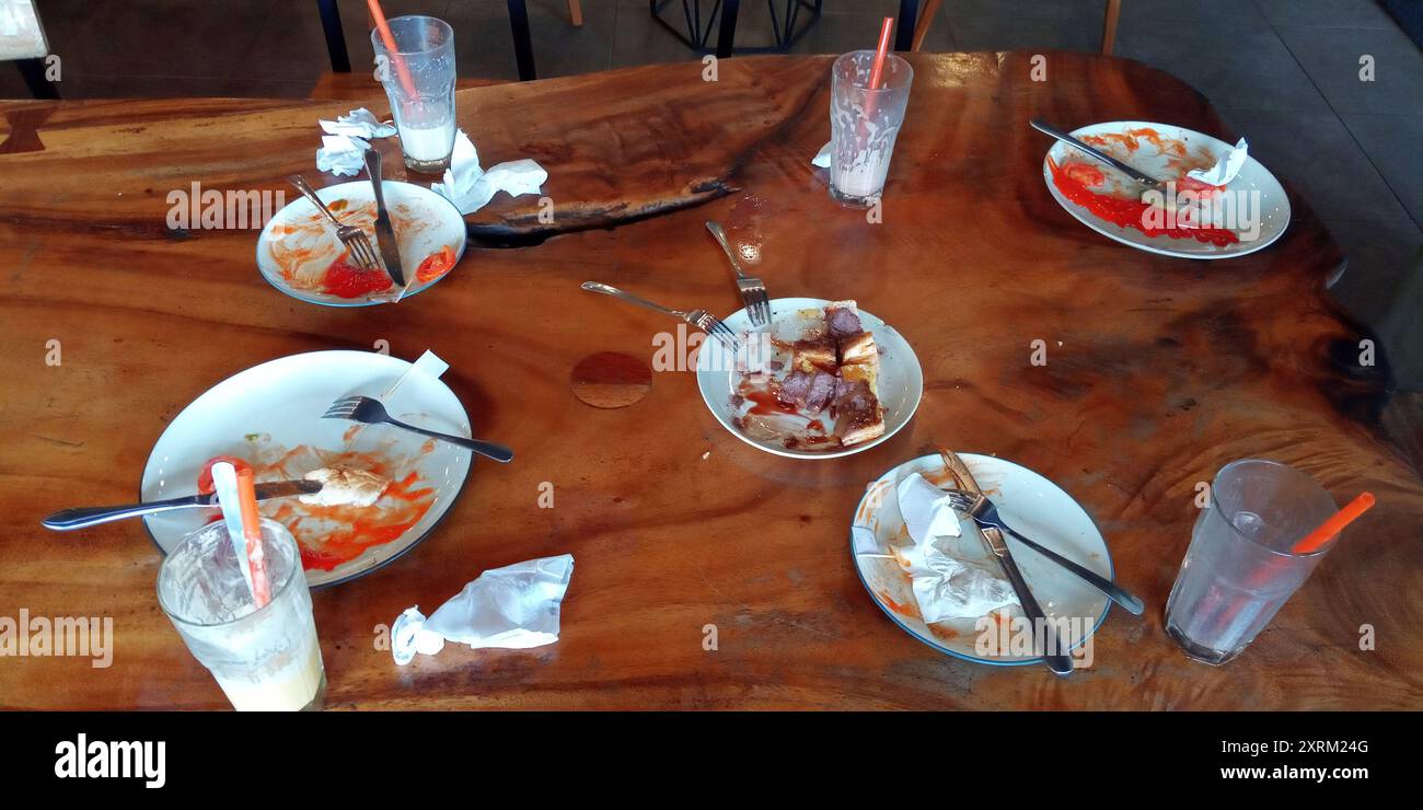 The leftover food and dirty empty dishes on the restaurant table ...
