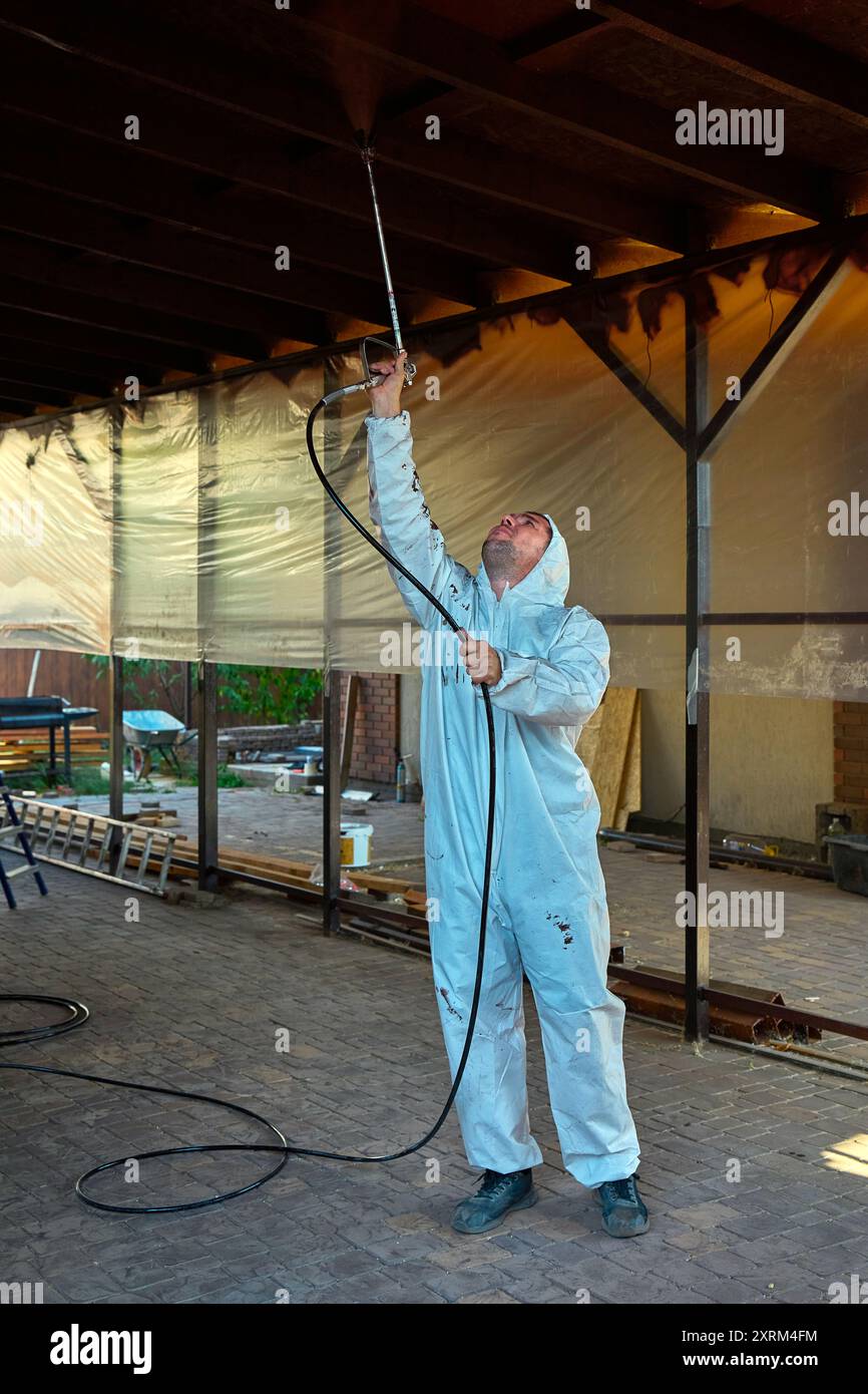 man paints a room with a spray gun Stock Photo - Alamy