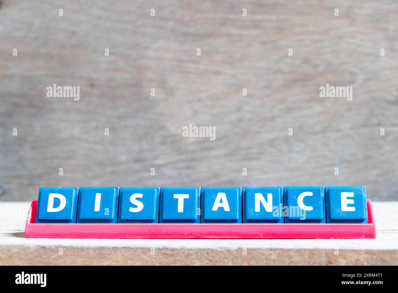 Tile alphabet letter with word distance in red color rack on wood ...