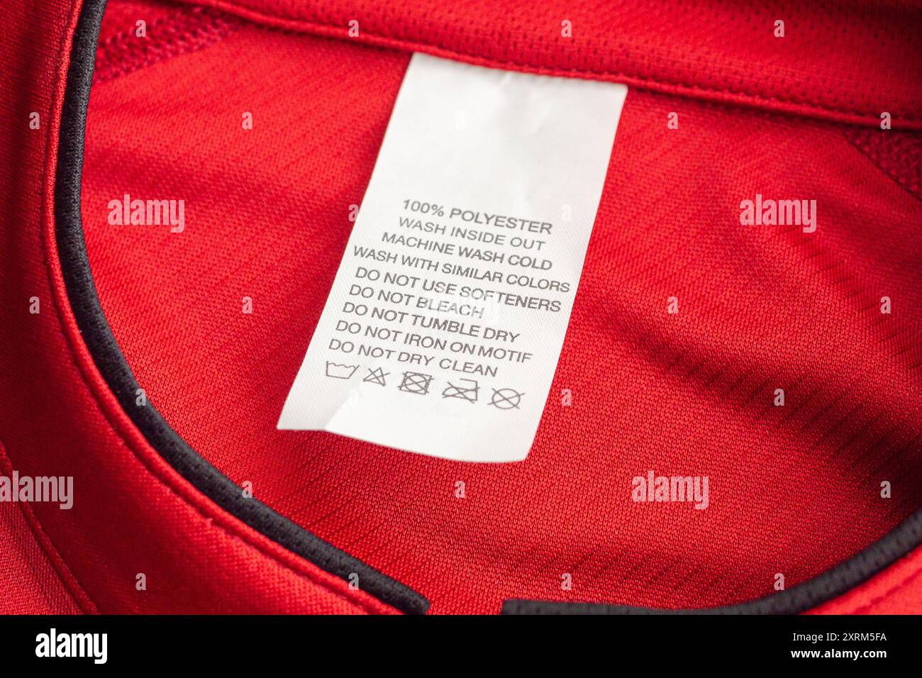 White laundry care washing instructions clothes label on red jersey ...