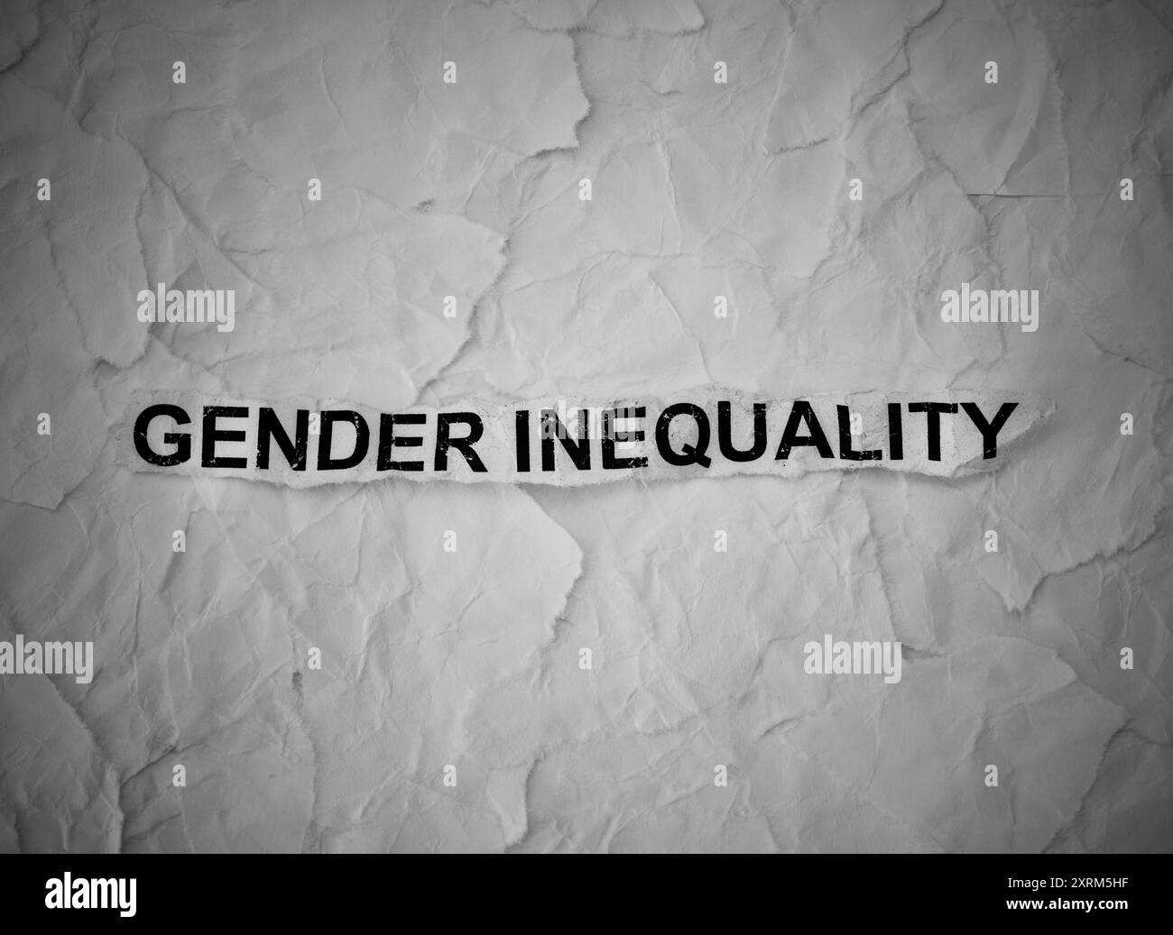 Crumpled piece of paper with words Gender Inequality on a torn white ...