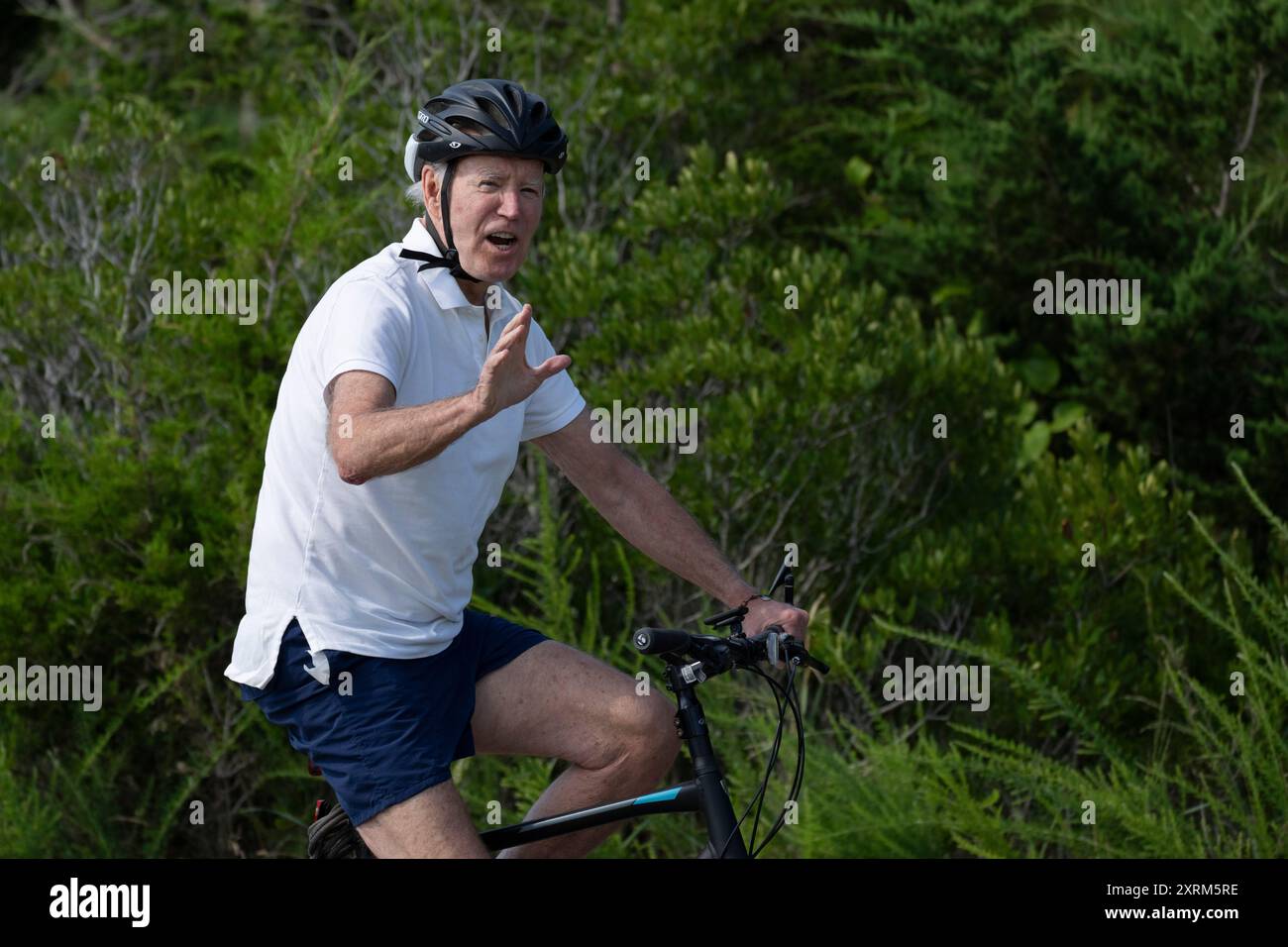 President Joe Biden waves as he rides his bike at Gordons Pond in ...