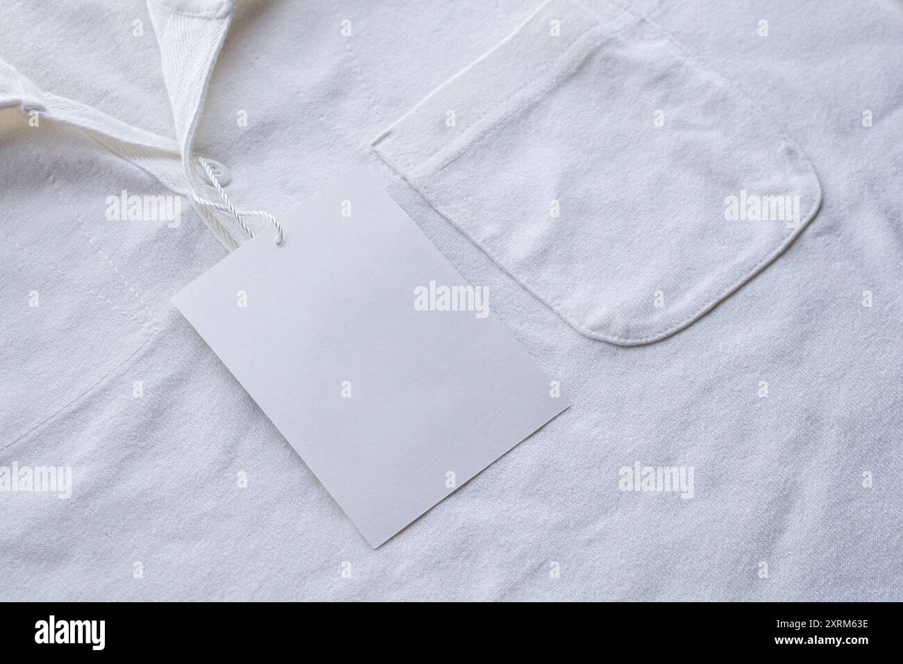 Blank white clothes tag label on new shirt Stock Photo - Alamy