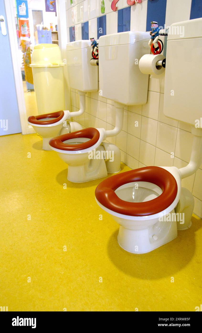 Small childrens toilet seats in a row in a nursery Stock Photo - Alamy