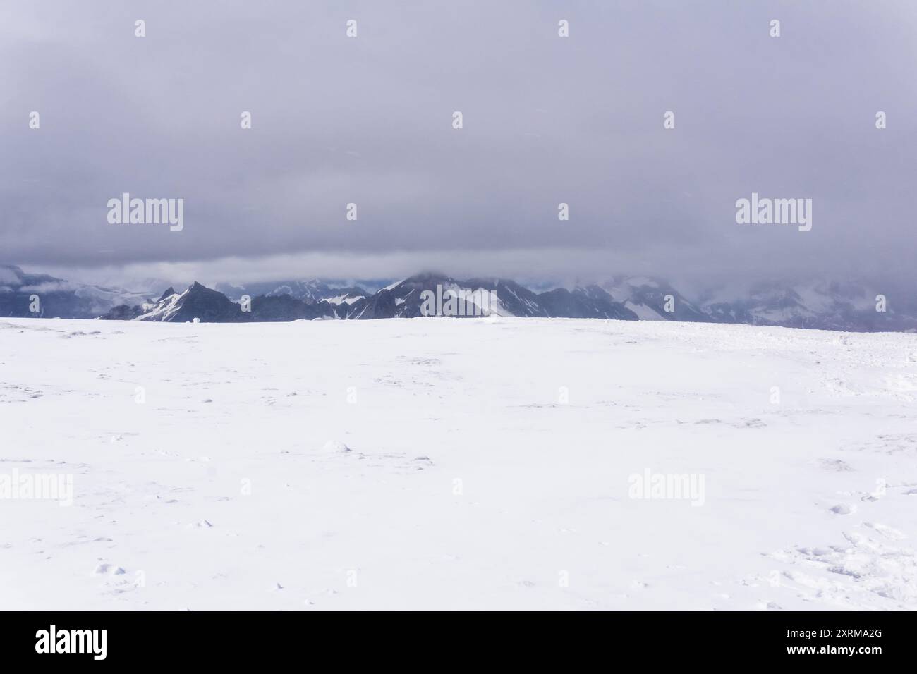 highland snowy plateau landscape, mountain range in clouds is visible ...