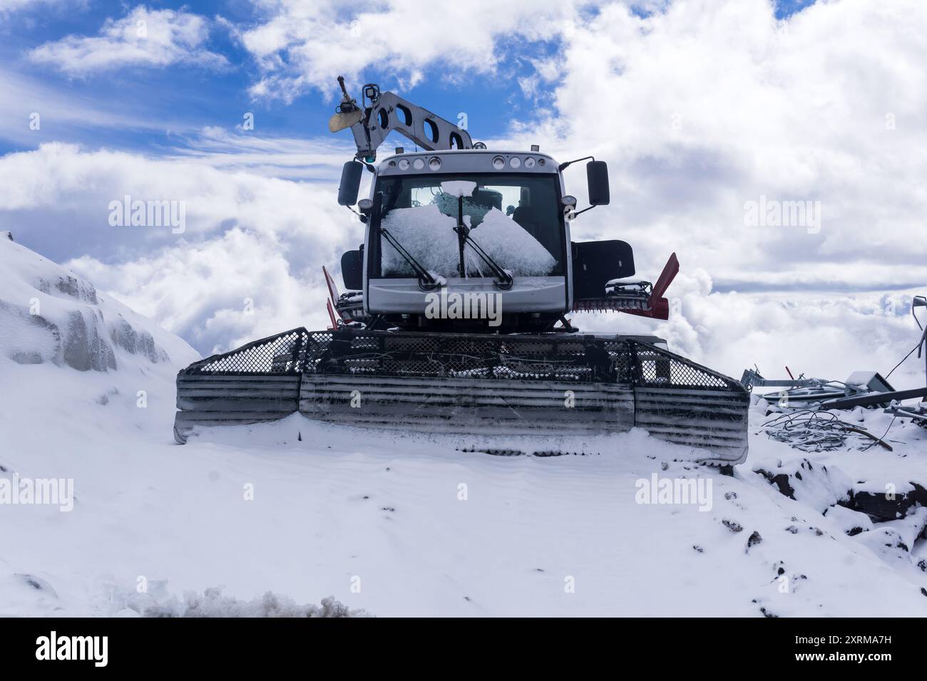 Snowcat in the snow in the highlands against the background of a blue ...