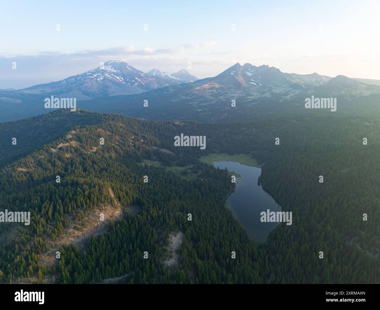 Dawn illuminates Todd Lake and Three Sisters mountains, Oregon, during ...