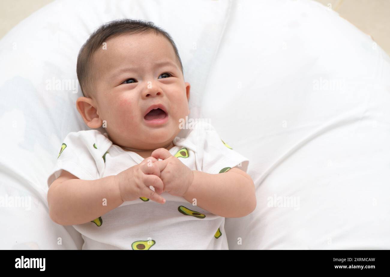 Asian infant crying baby. child tired and hungry in mother arms ...
