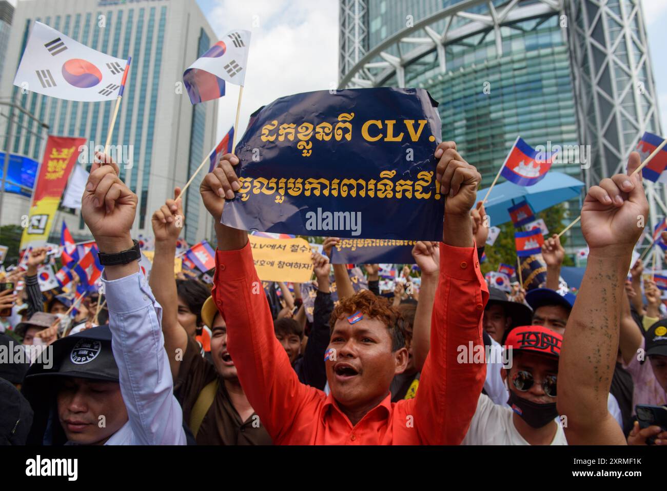 Cambodians living in South Korea are seen holding flags and placards ...