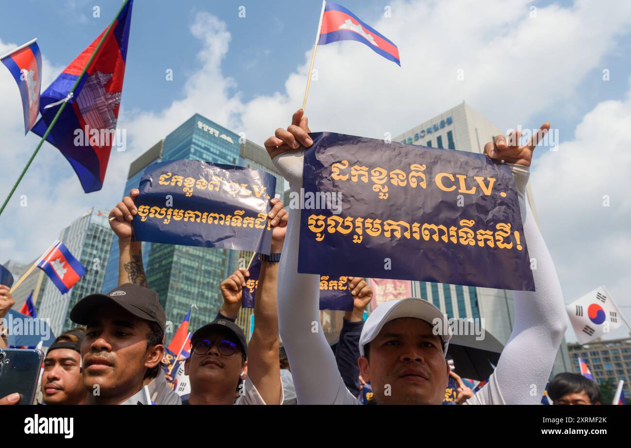 Cambodians living in South Korea are seen holding flags and placards ...