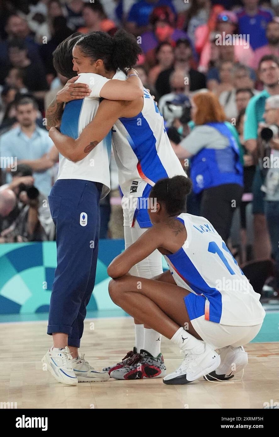 Members of the French team hug on the court after being defeated by the ...